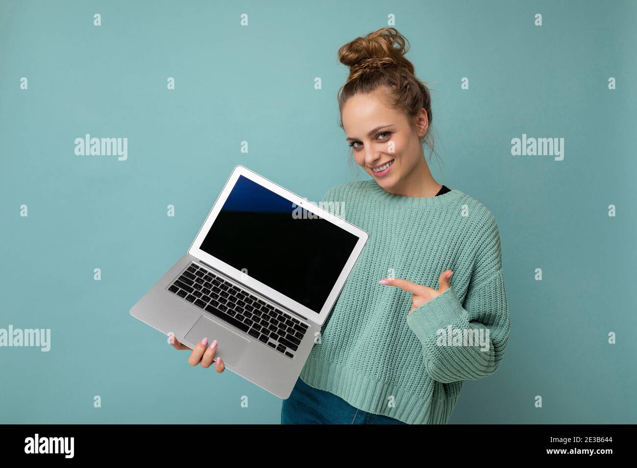 beautiful dark blond young woman with gathered curly hair looking at ...