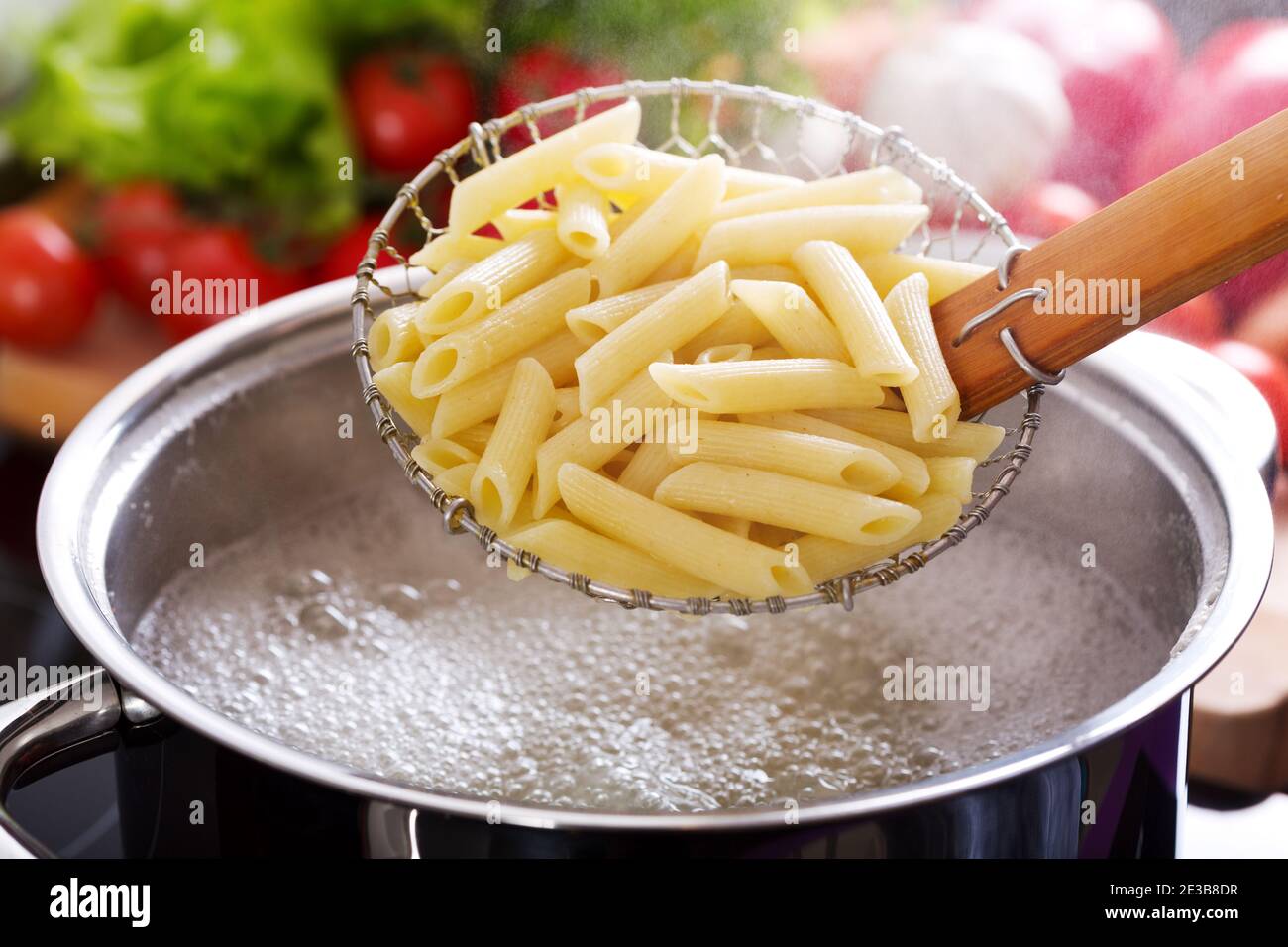 Cooking pasta in a pot with boiling water on a cooker on a kitchen ...