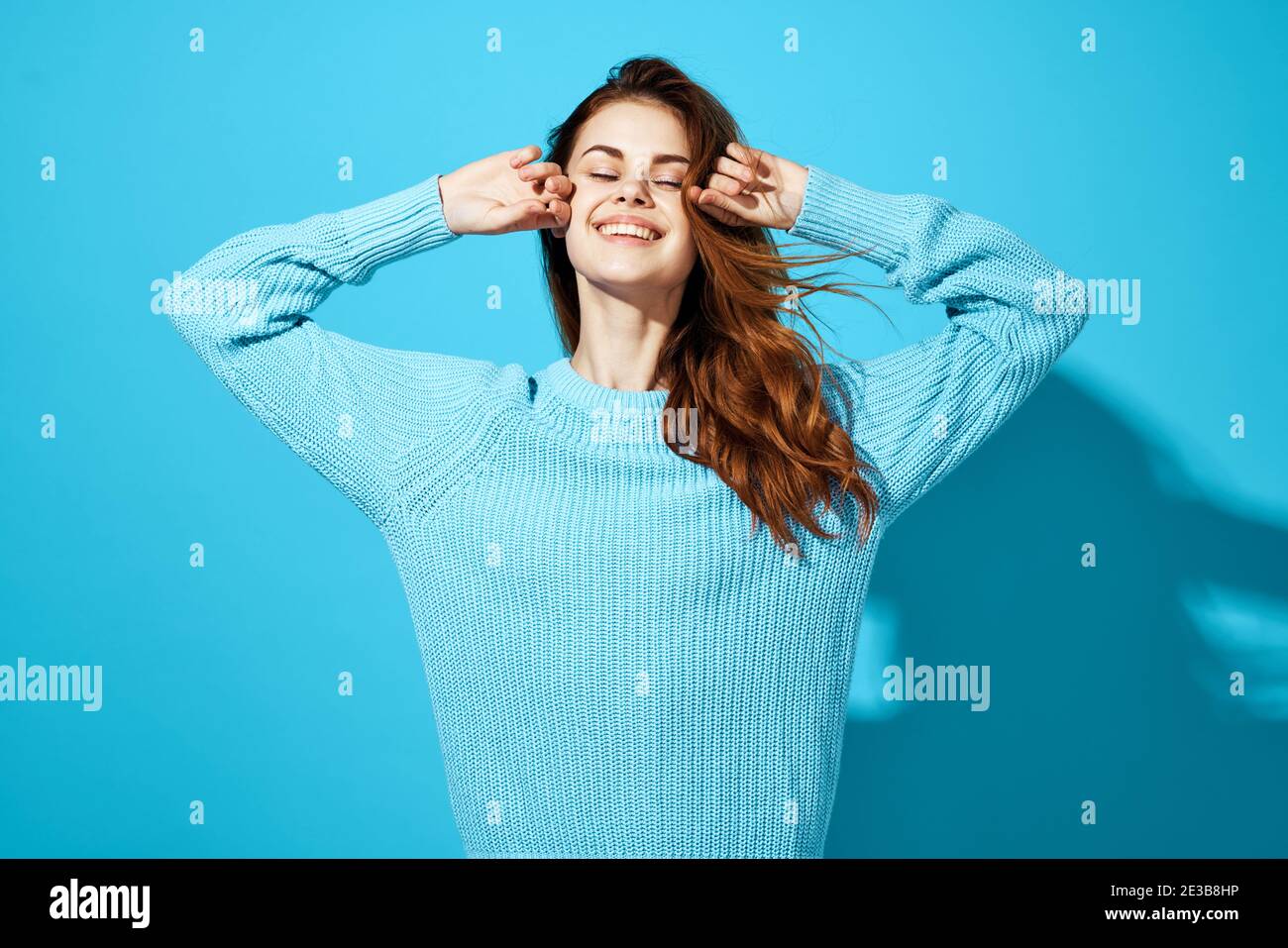 pretty woman in blue sweater gesturing with hands emotions casual ...