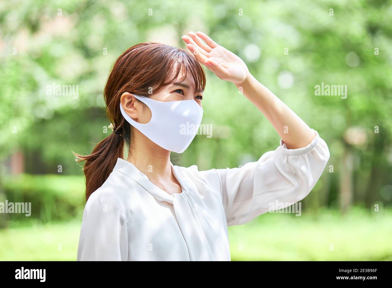 Young Japanese businesswoman wearing mask in the hot Summer downtown ...