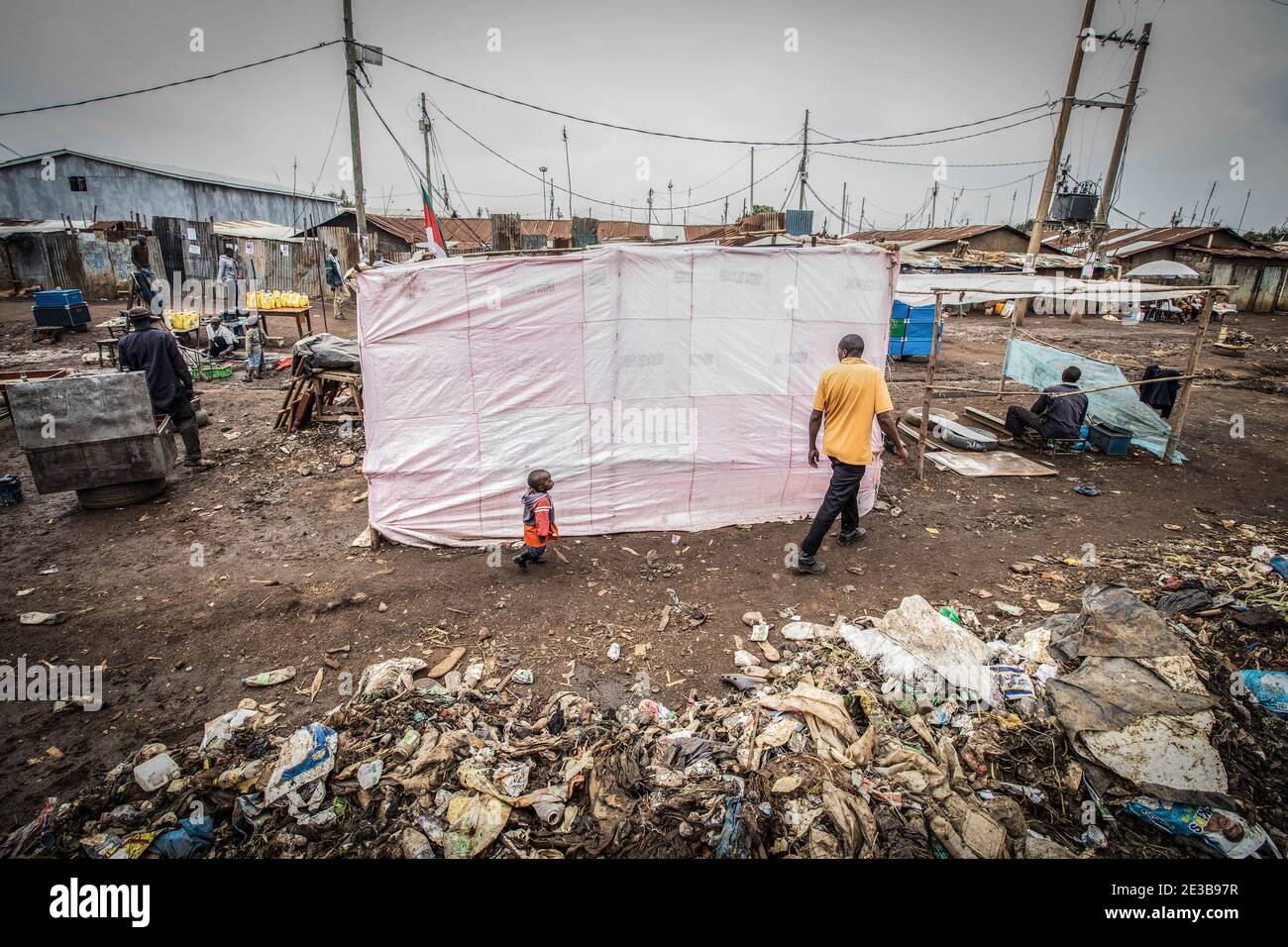 A father and his son are seen walking past a local Church tent made ...