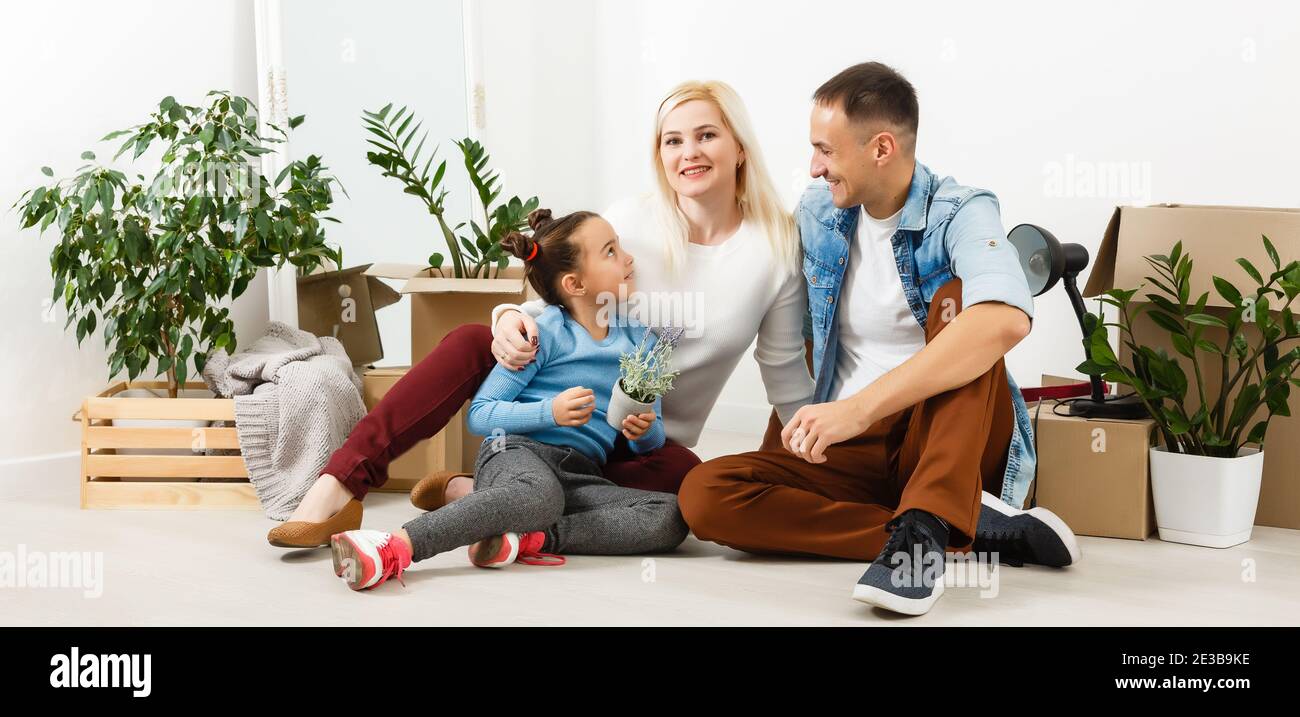 Family unpacking cardboard boxes at new home Stock Photo - Alamy
