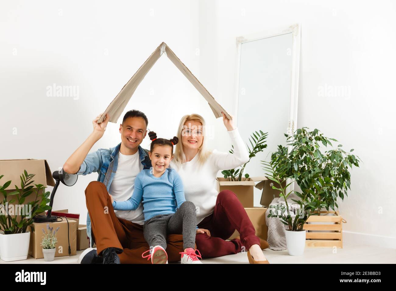 Happy young family under a safe roof, concept Stock Photo - Alamy