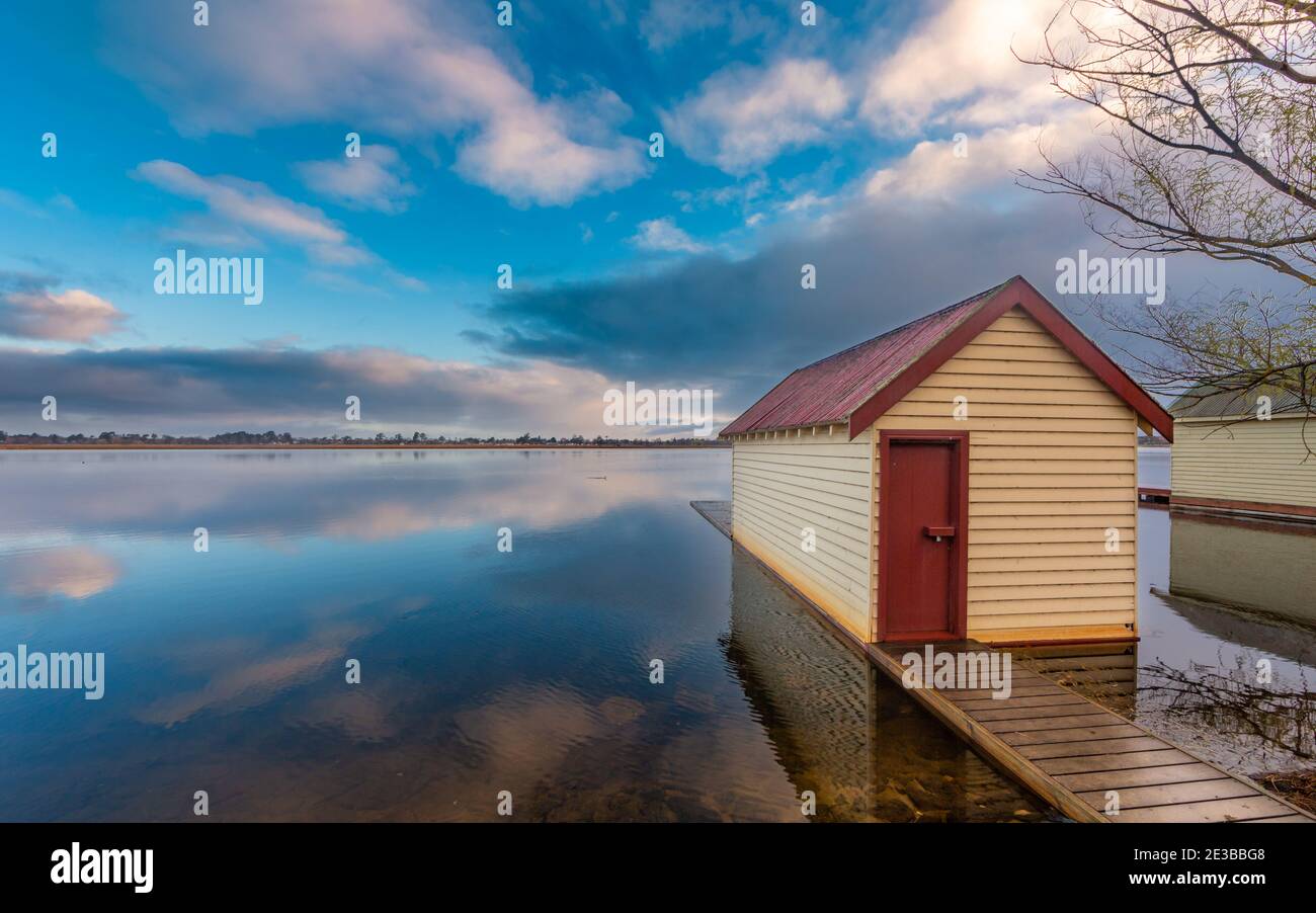 Lakeside Boathouse with Red Roof and Reflections Stock Photo - Alamy