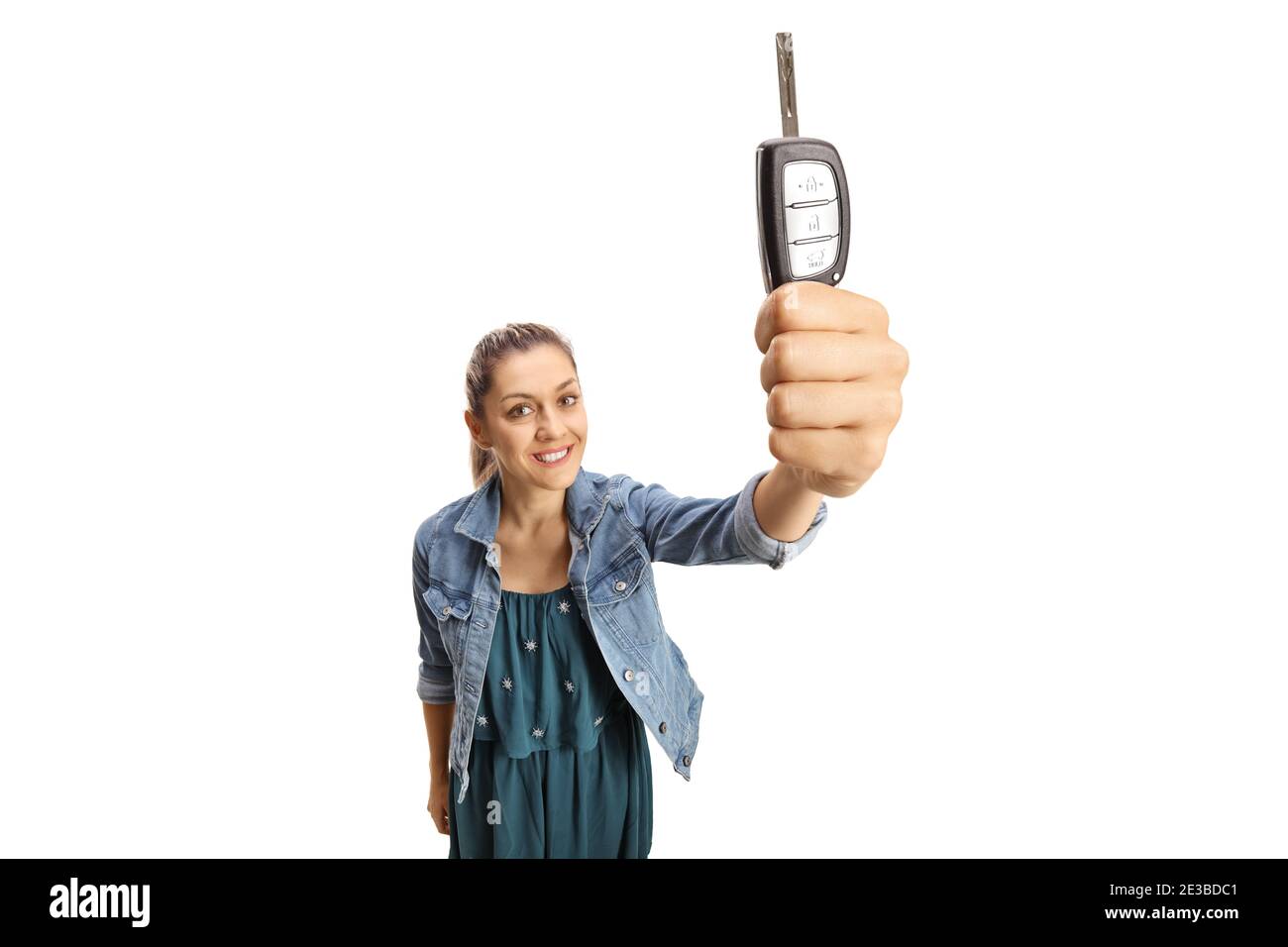 Casual young woman showing car key in front of camera isolated on white ...
