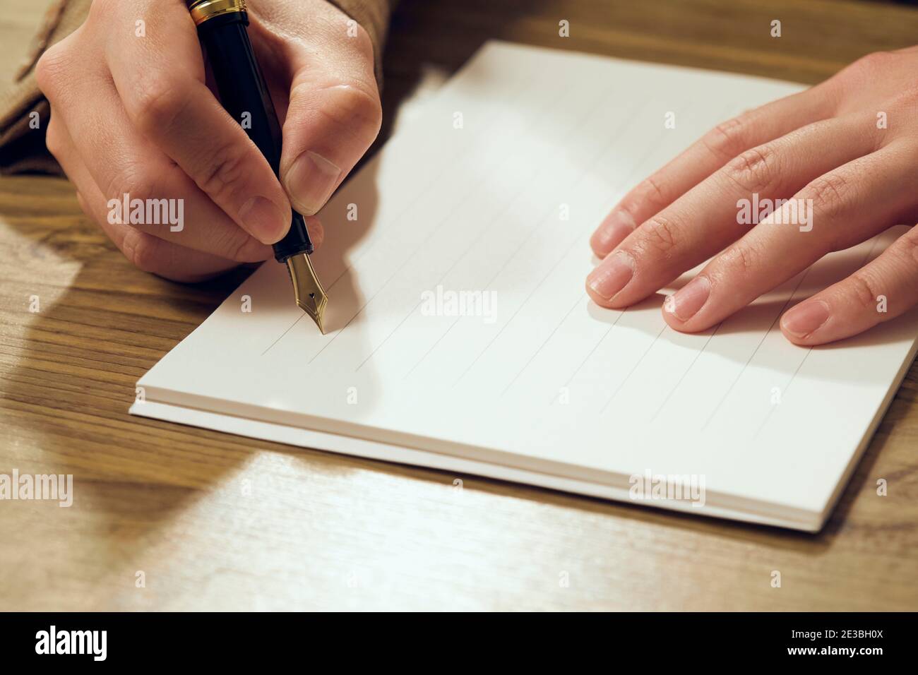 Man writing on paper Stock Photo - Alamy