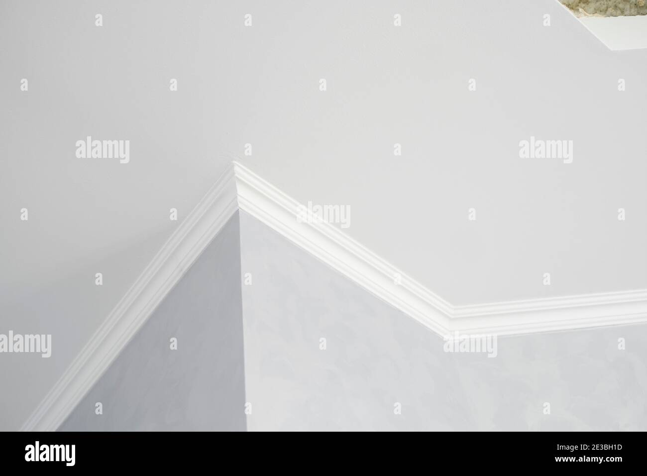 White ceiling with a white plinth in a room with gray painted walls ...