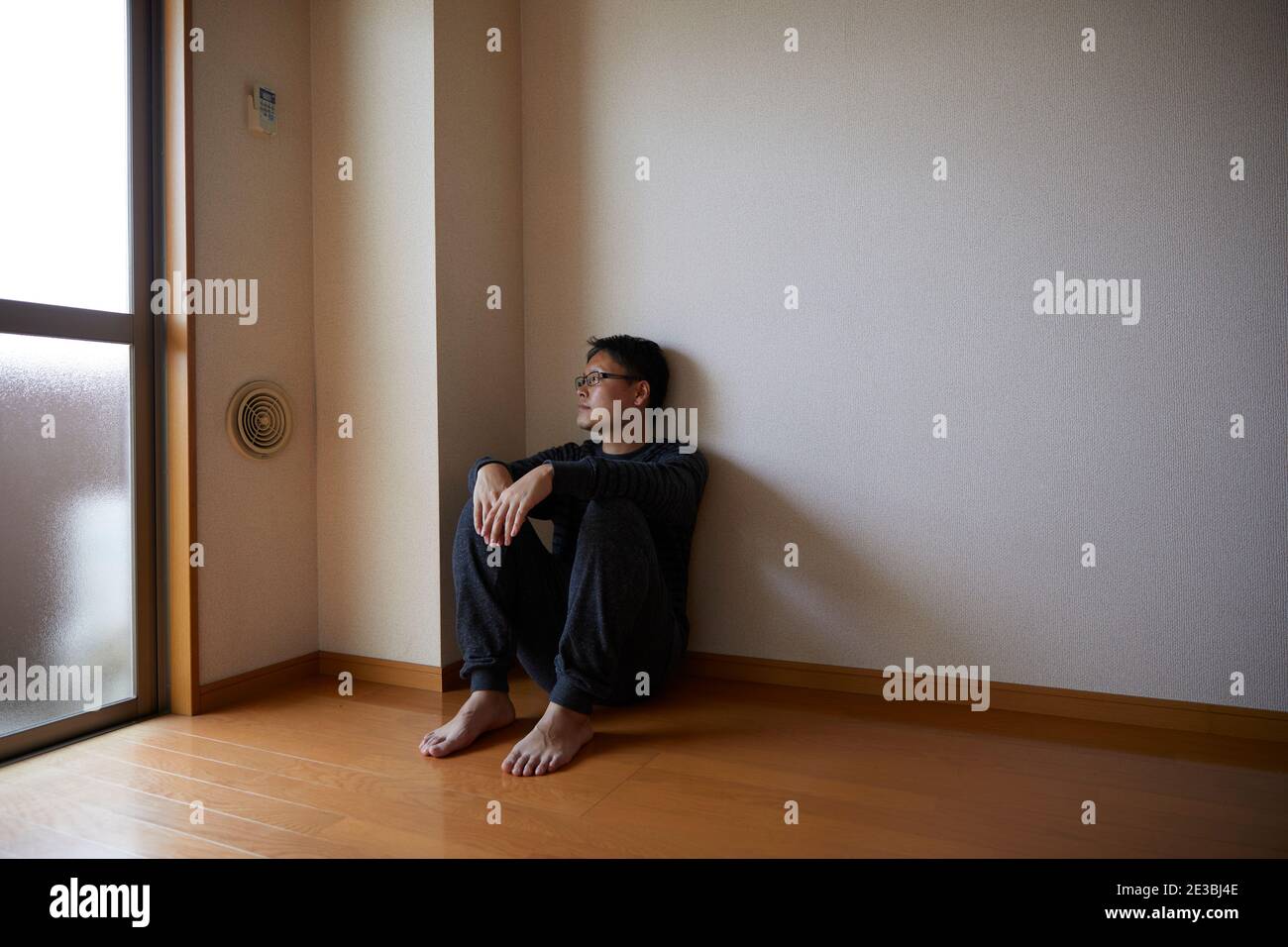 Sad Japanese man in empty apartment Stock Photo - Alamy