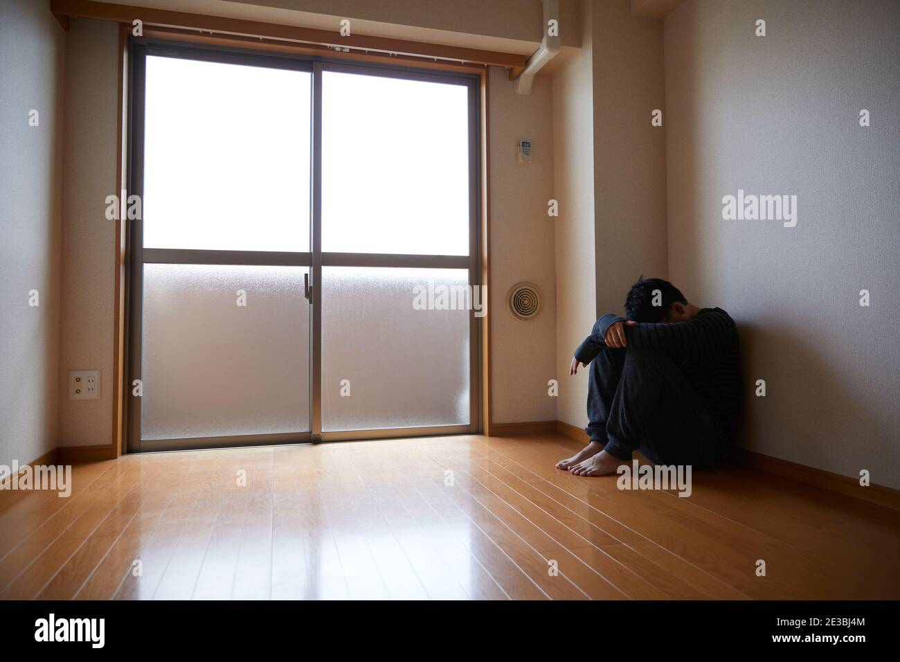 Sad Japanese man in empty apartment Stock Photo - Alamy