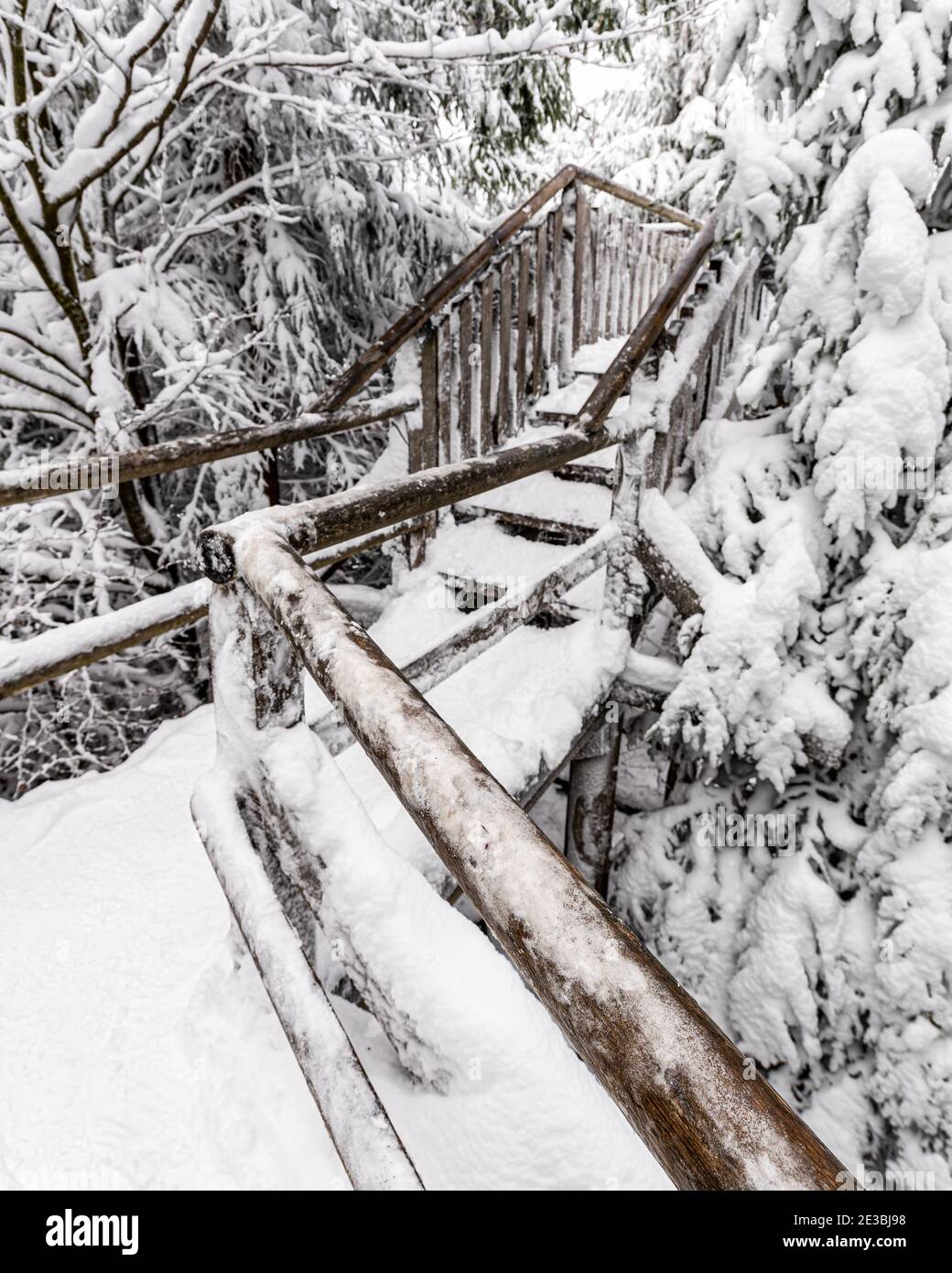 Vertical shot of a wooden bridge covered in snow in the Black Forest ...