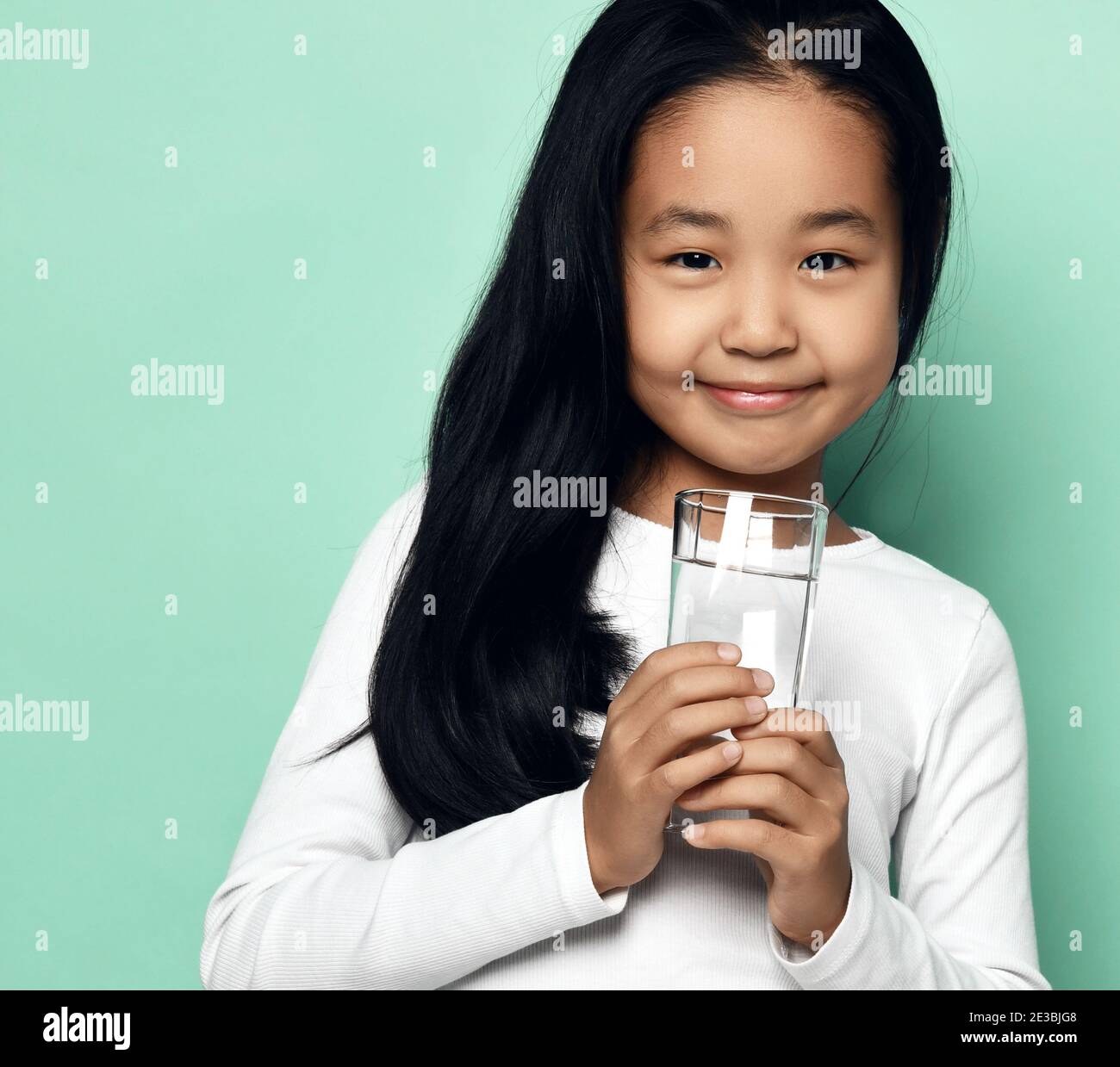 Health and beauty concept - smiling little asian girl kid with glass of ...