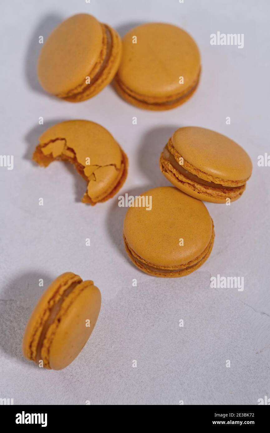 Apricot macarons lying on a white table top, flatlay, white background ...