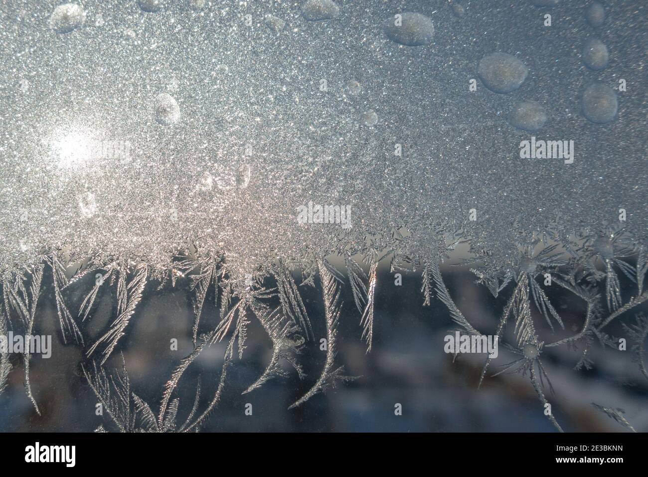 Frozen window in winter time. Frost pattern on the window. Icy flowers ...