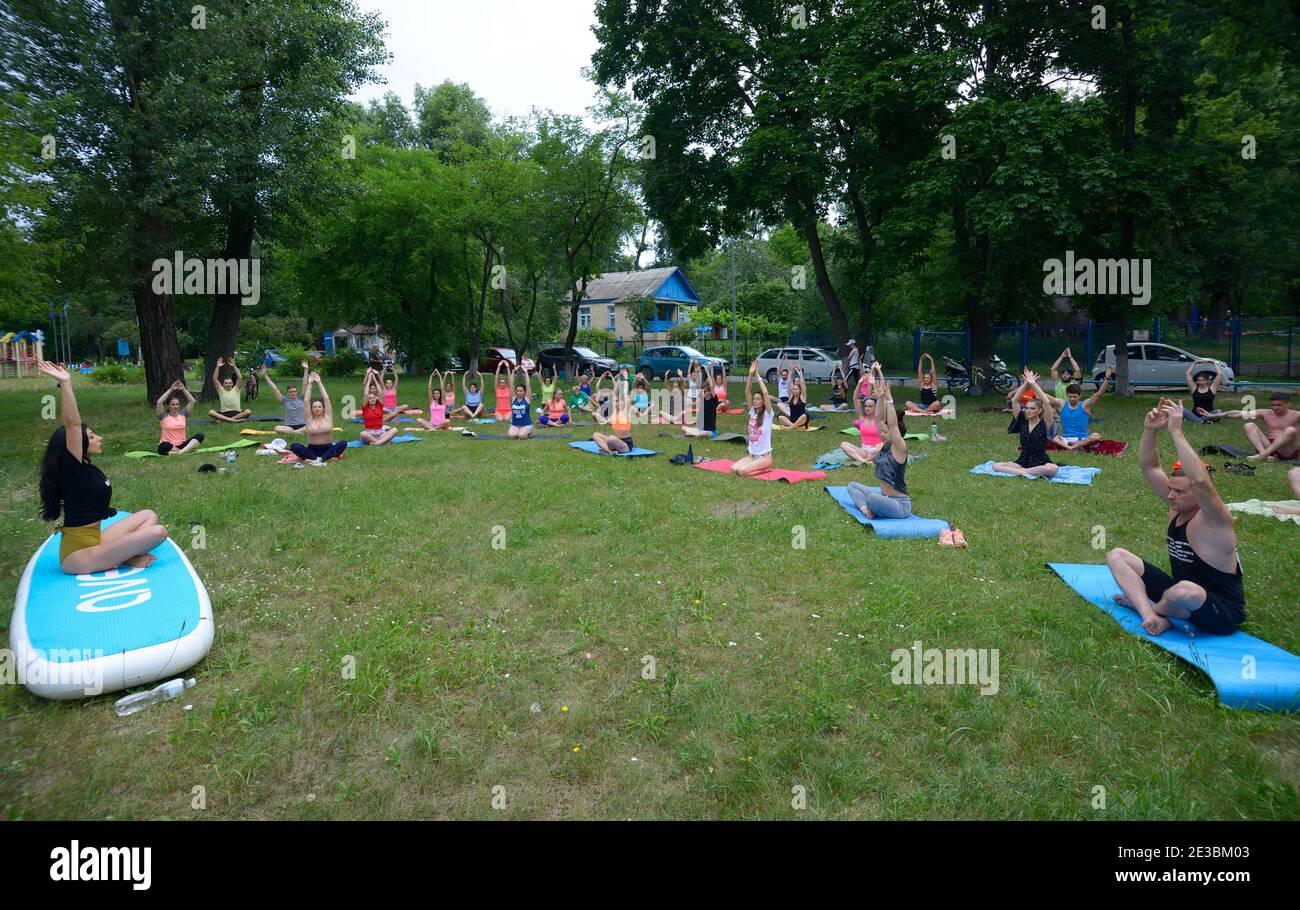 Group of people doing morning stretching exercises at the city park ...