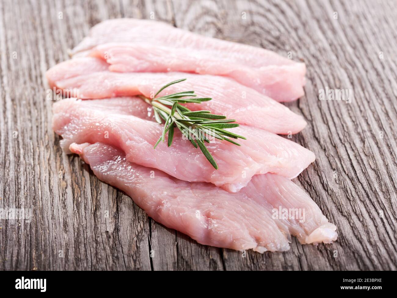 fresh turkey fillet with rosemary on wooden table Stock Photo - Alamy