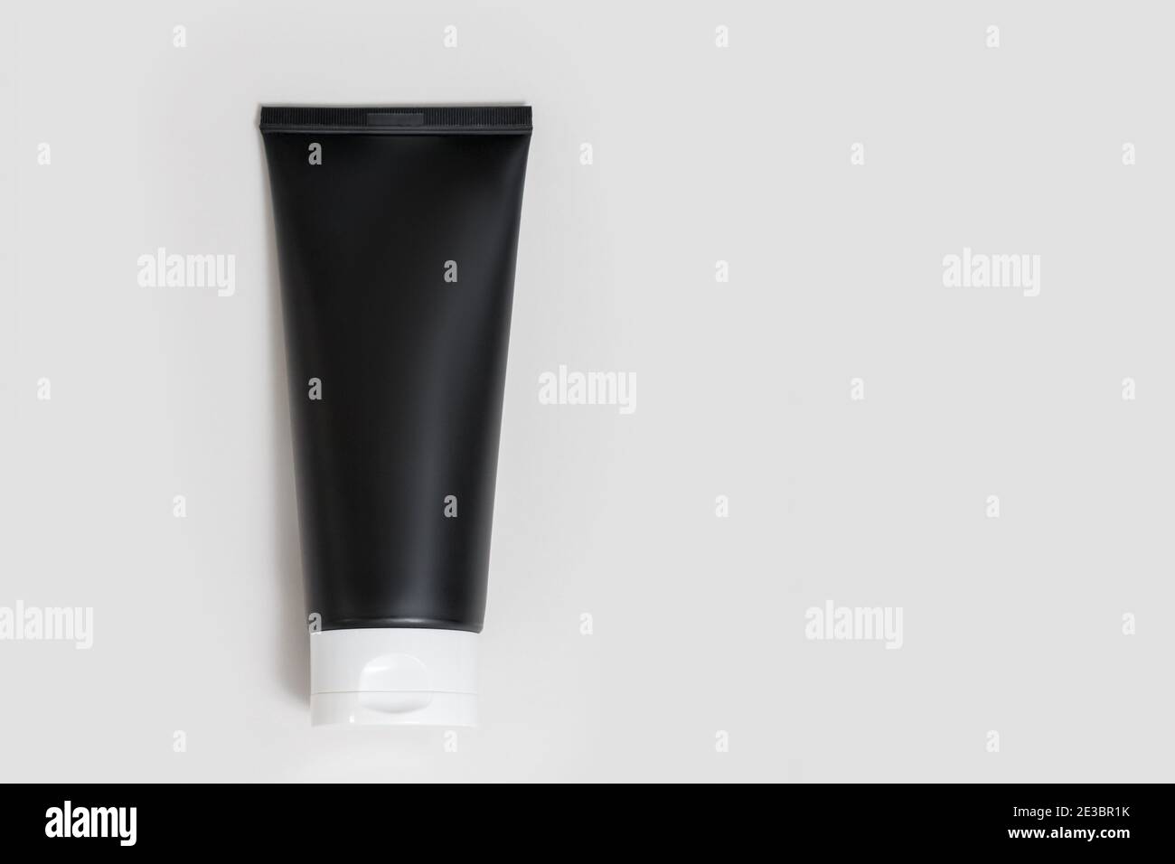 Black cream tubes on a light gray background. Cosmetic product for the ...