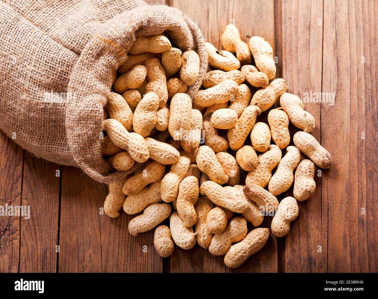 peanuts in a sack on wooden table, top view Stock Photo - Alamy