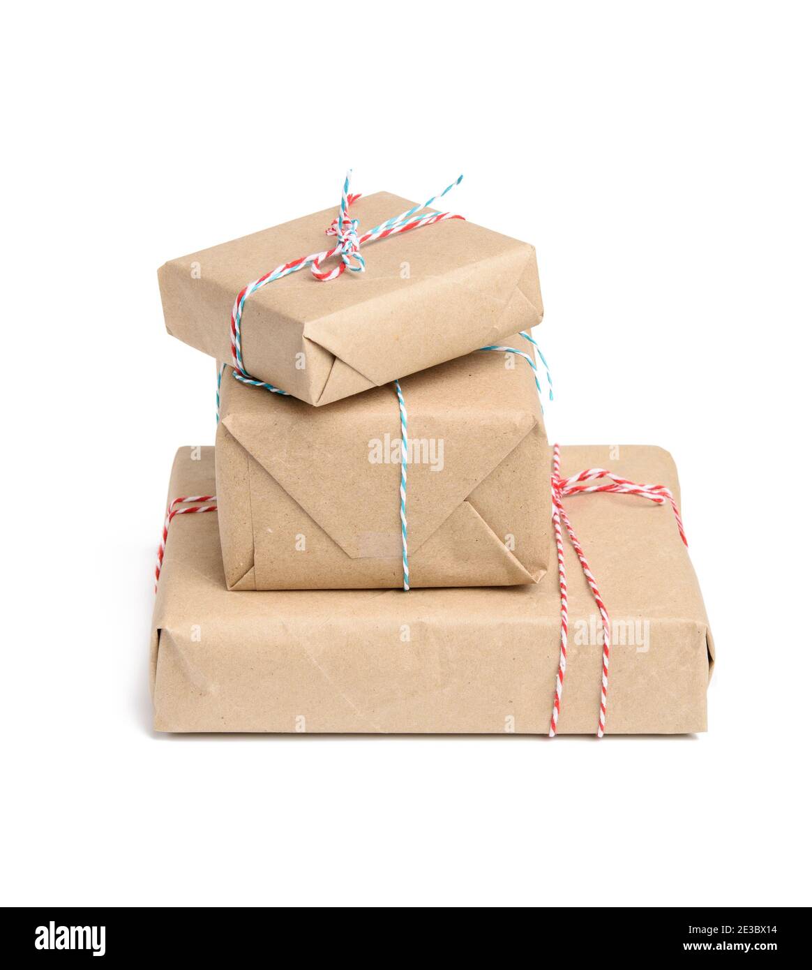 big stack of gifts wrapped in brown kraft paper and tied with rope ...