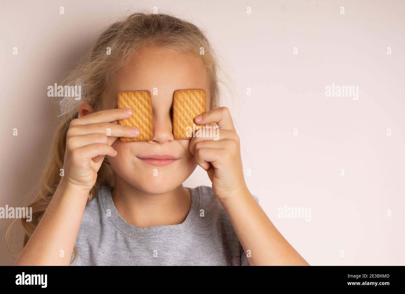 Full of sweet taste. Cute little girl having fun with cookies. The ...