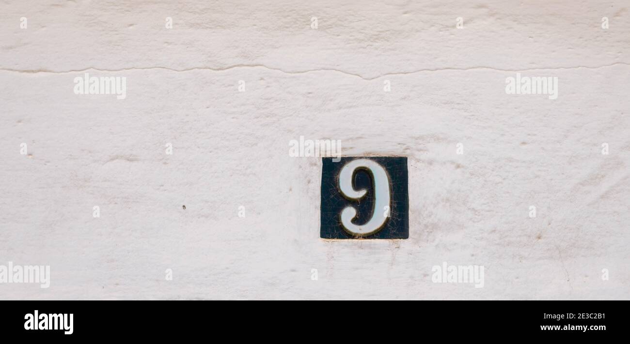 Decorative ceramic house number 9 tile on the wall, characteristic ...