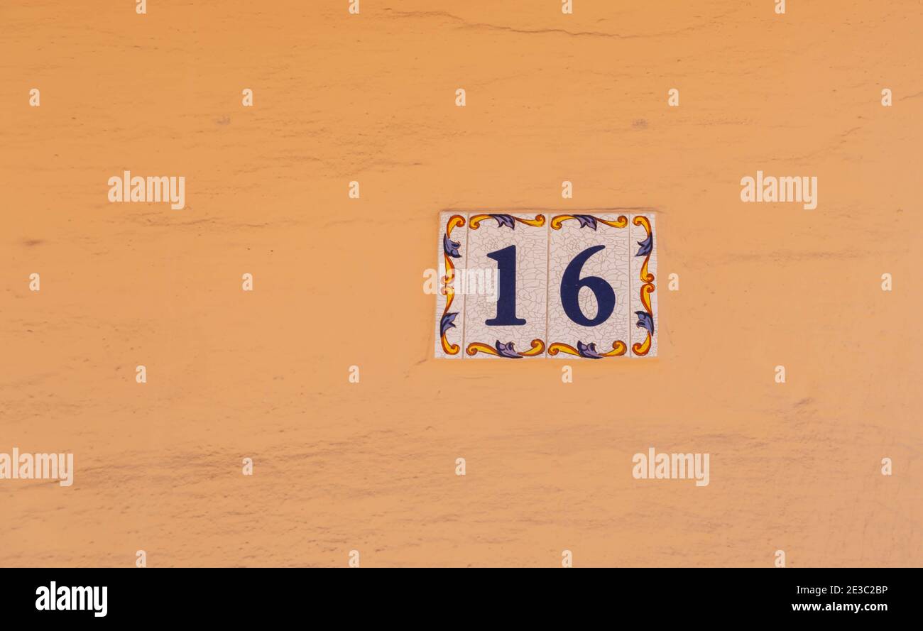 Decorative ceramic house number 16 tile on the wall, characteristic ...
