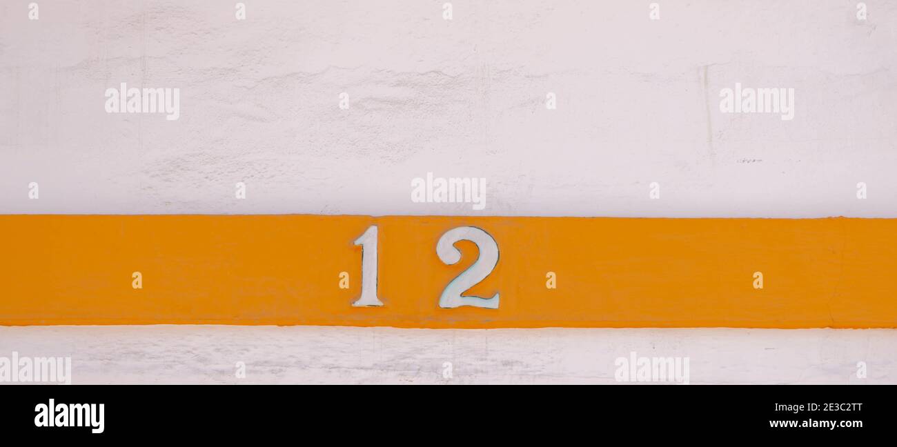 Decorative ceramic house number 12 tile on the wall, characteristic ...