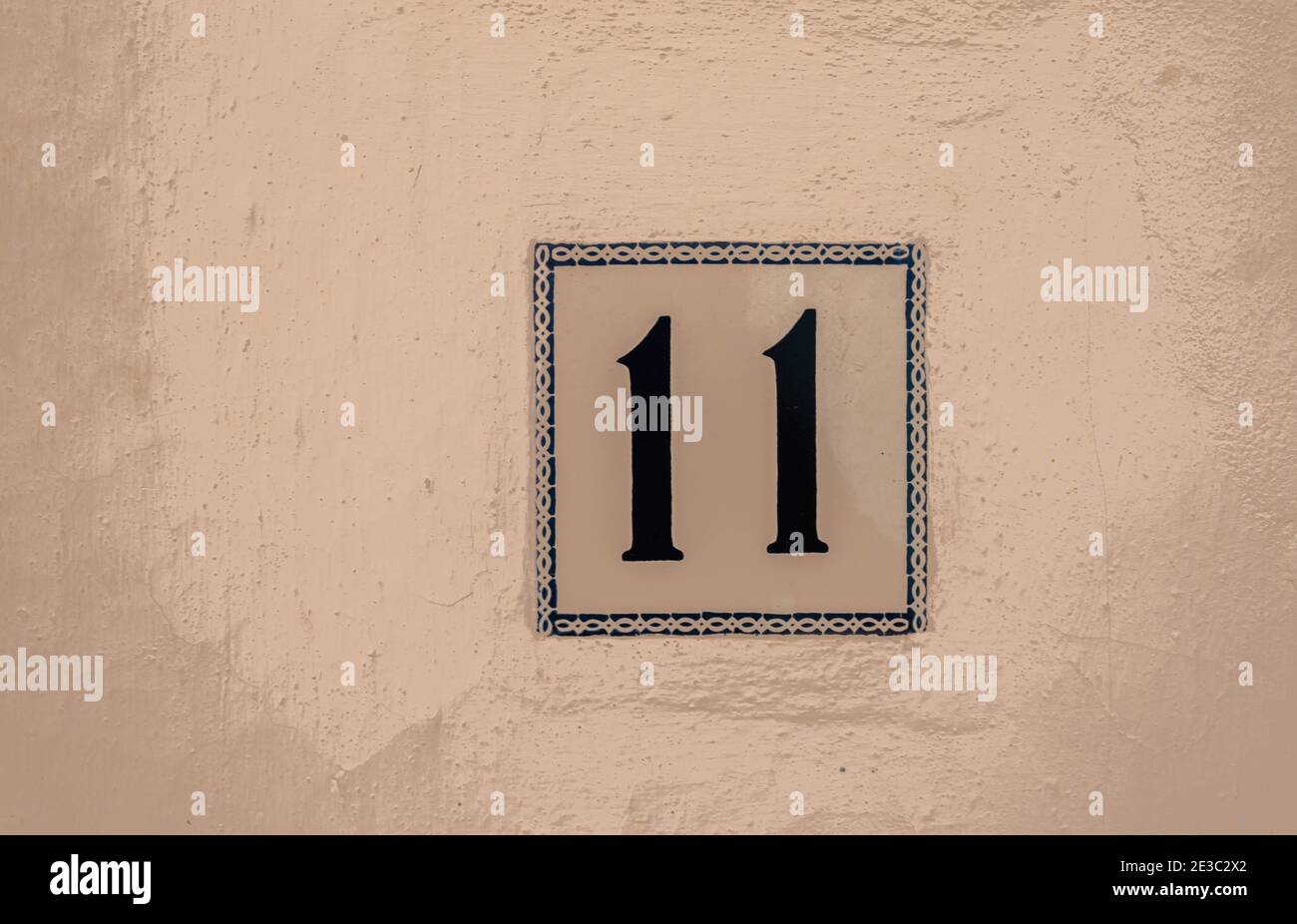 Decorative ceramic house number 11 tile on the wall, characteristic ...