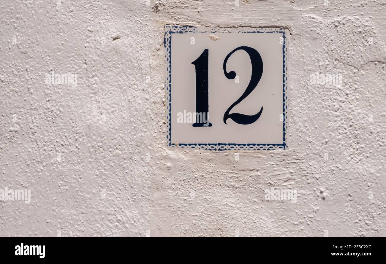 Decorative ceramic house number 12 tile on the wall, characteristic ...