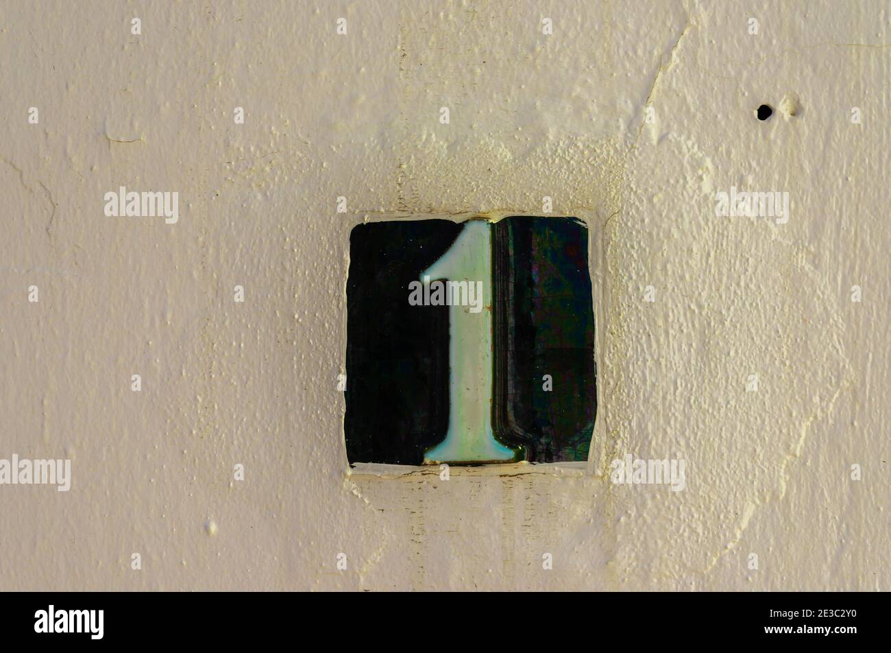 Decorative ceramic house number 1 tile on the wall, characteristic ...