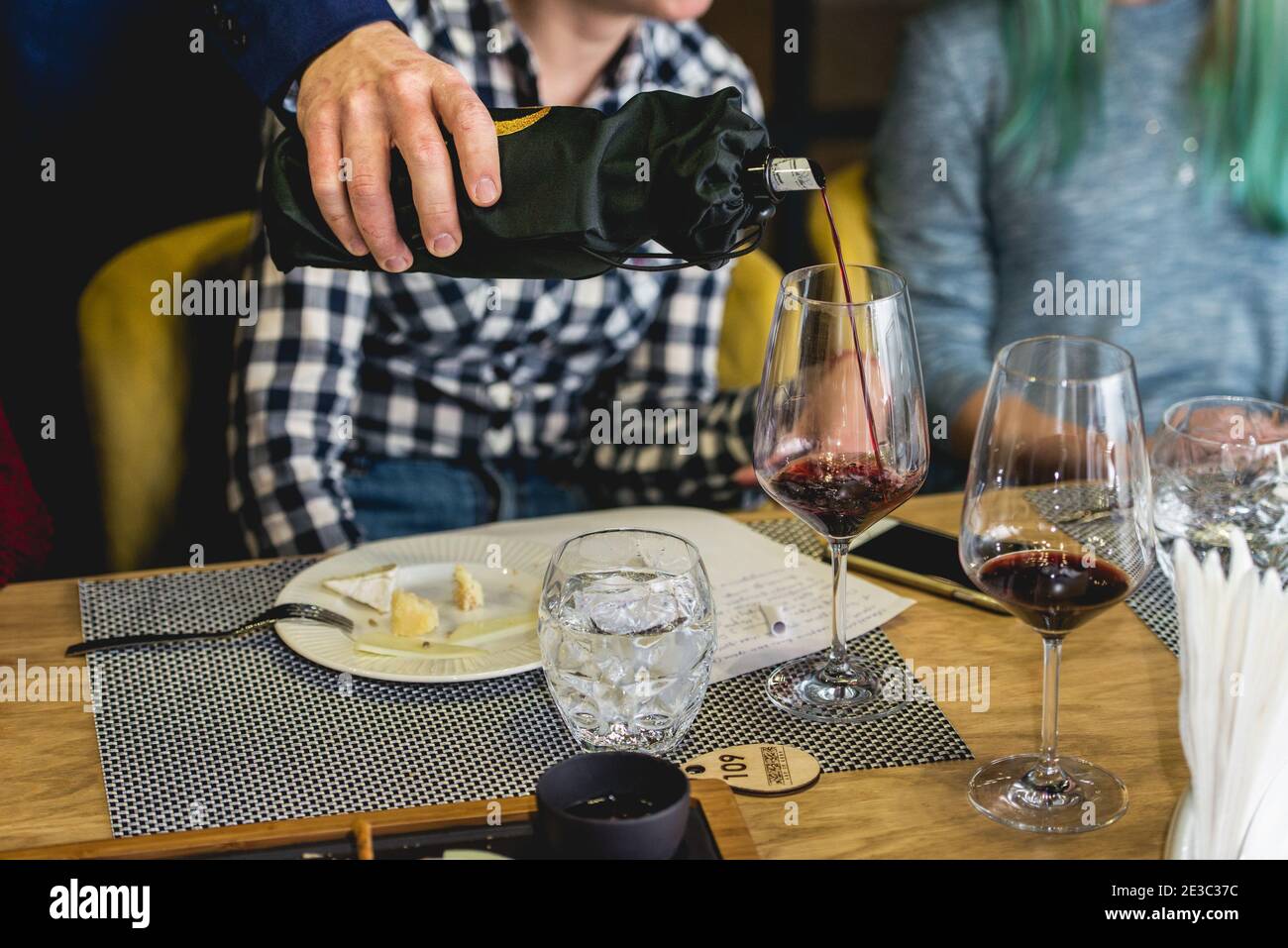 Served table at wine tasting. sommelier at wine tasting pouring red ...