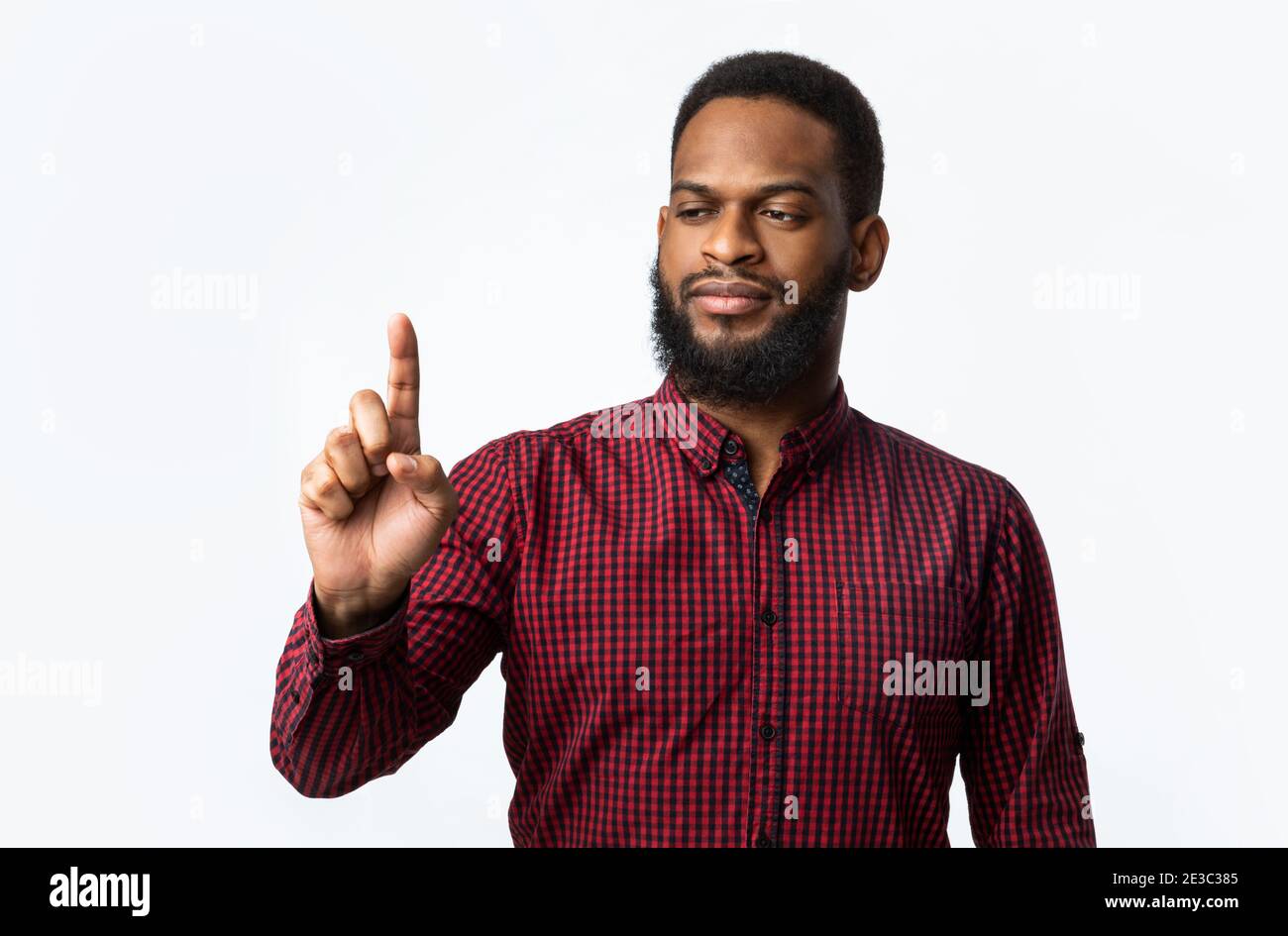 African Man Looking At Finger Holding Invisible Object, Studio Shot ...