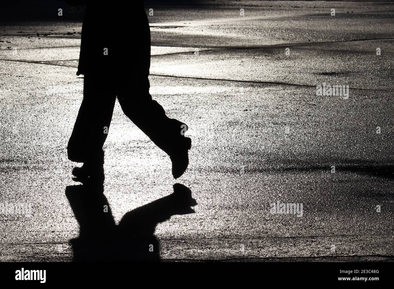 Black silhouette and shadow of woman walking down on a street. Concept ...
