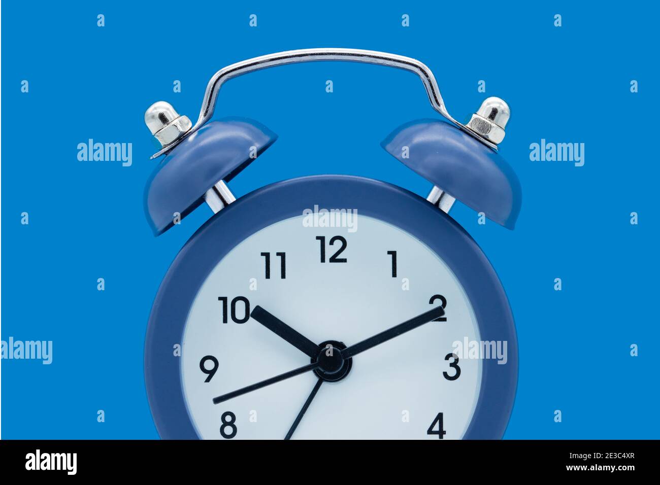 Classic alarm clock isolated on blue background Stock Photo - Alamy