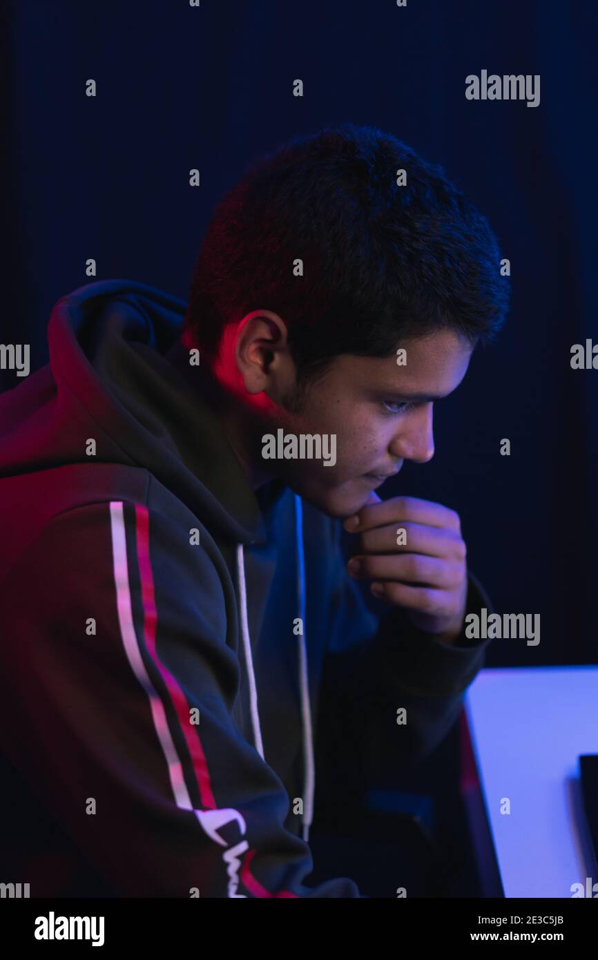 Shallow focus of a young Hispanic male gamer doing a live video game ...