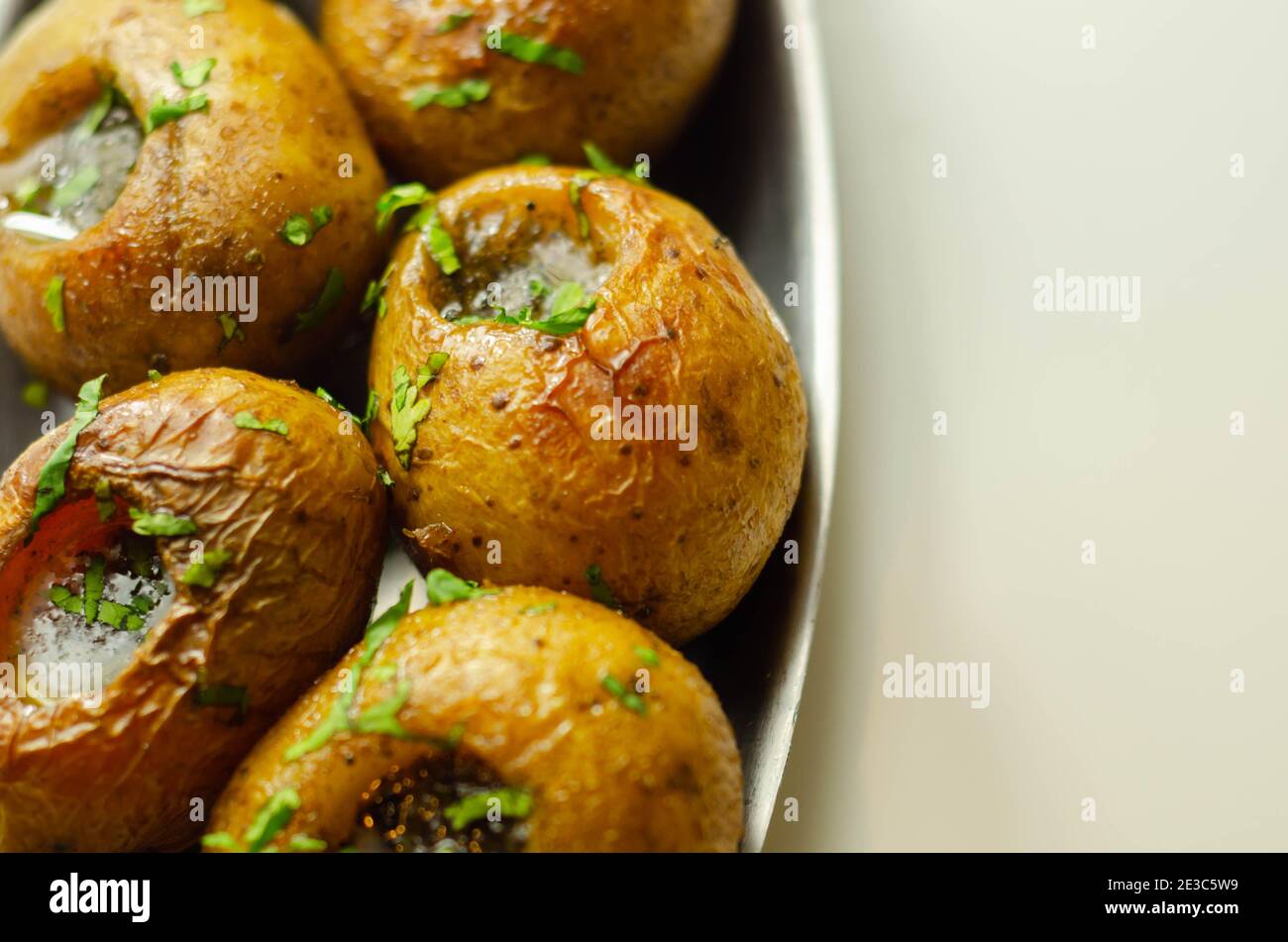 Mini jacket potatoes with a fragrant garlic butter infused with Italian ...