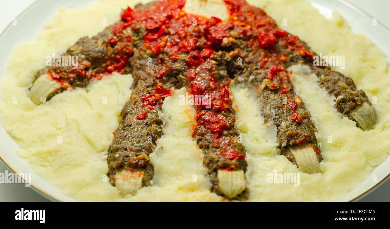 Roasted minced meat formed in the shape of a hand, topped with a tomato ...