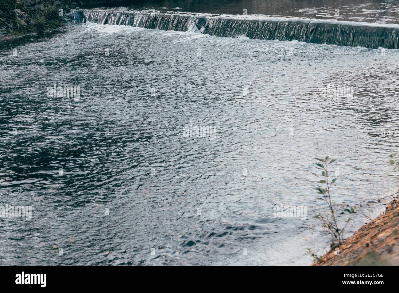 Wide river on summer day. Water flow on dam Stock Photo - Alamy