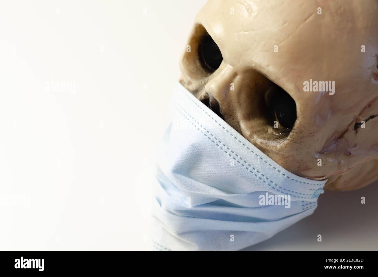 Scary human skull wearing a medical mask, symbolic depiction of death ...