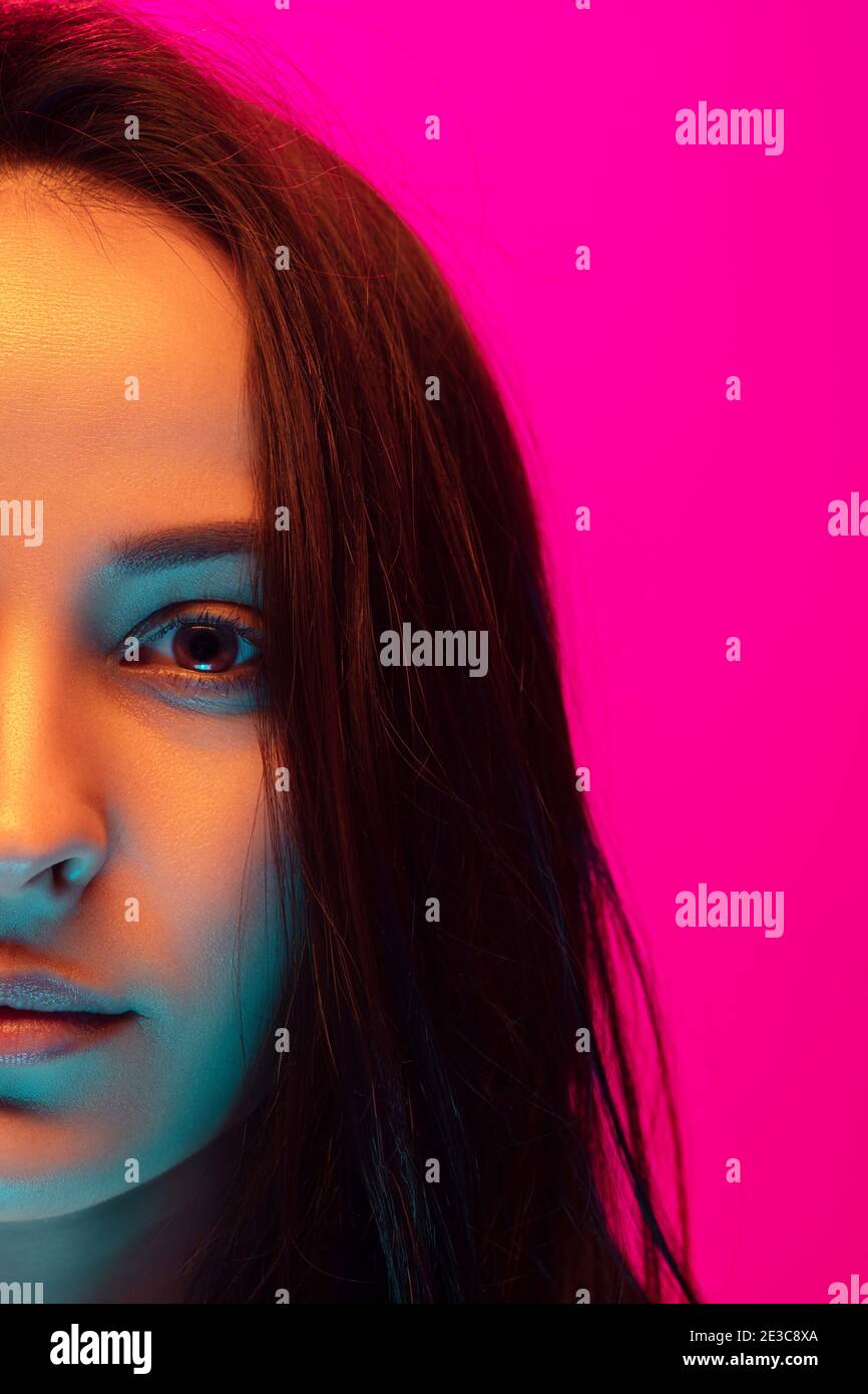 Close up half-full caucasian woman's portrait isolated on pink studio ...