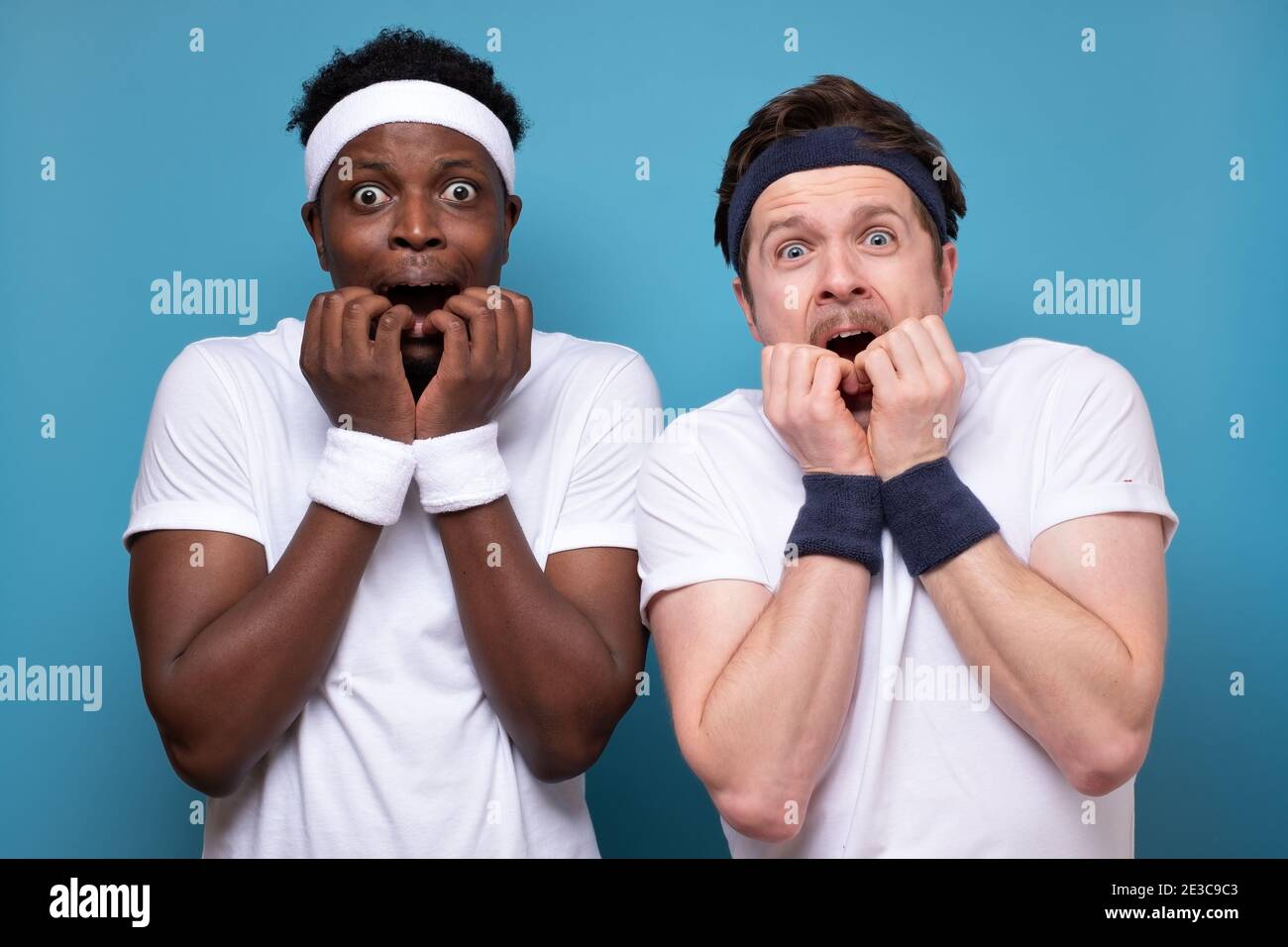 Nervous young european and african men freaking out biting nails ...