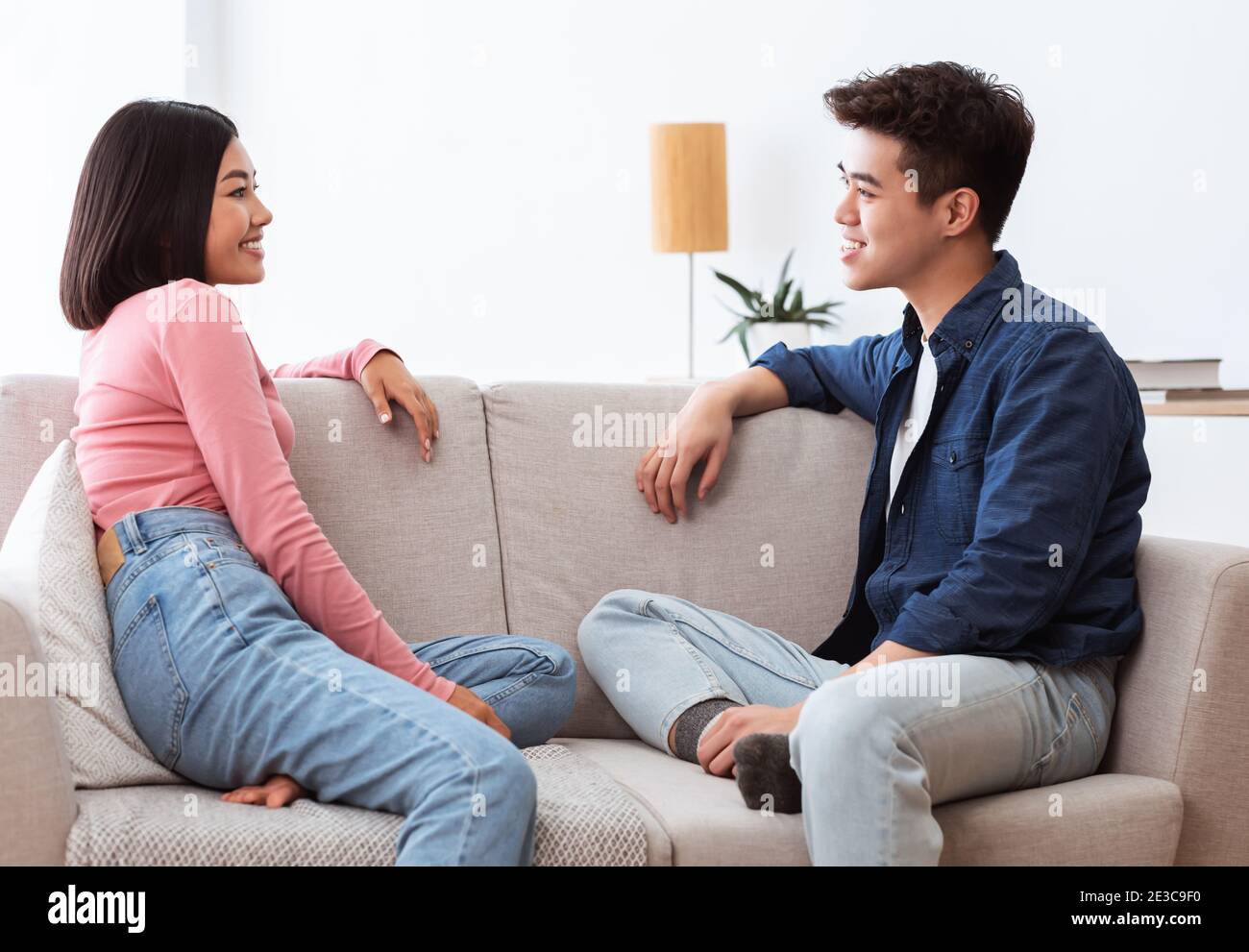Lovely Asian Couple Talking Enjoying Flirt Sitting On Sofa Indoor Stock