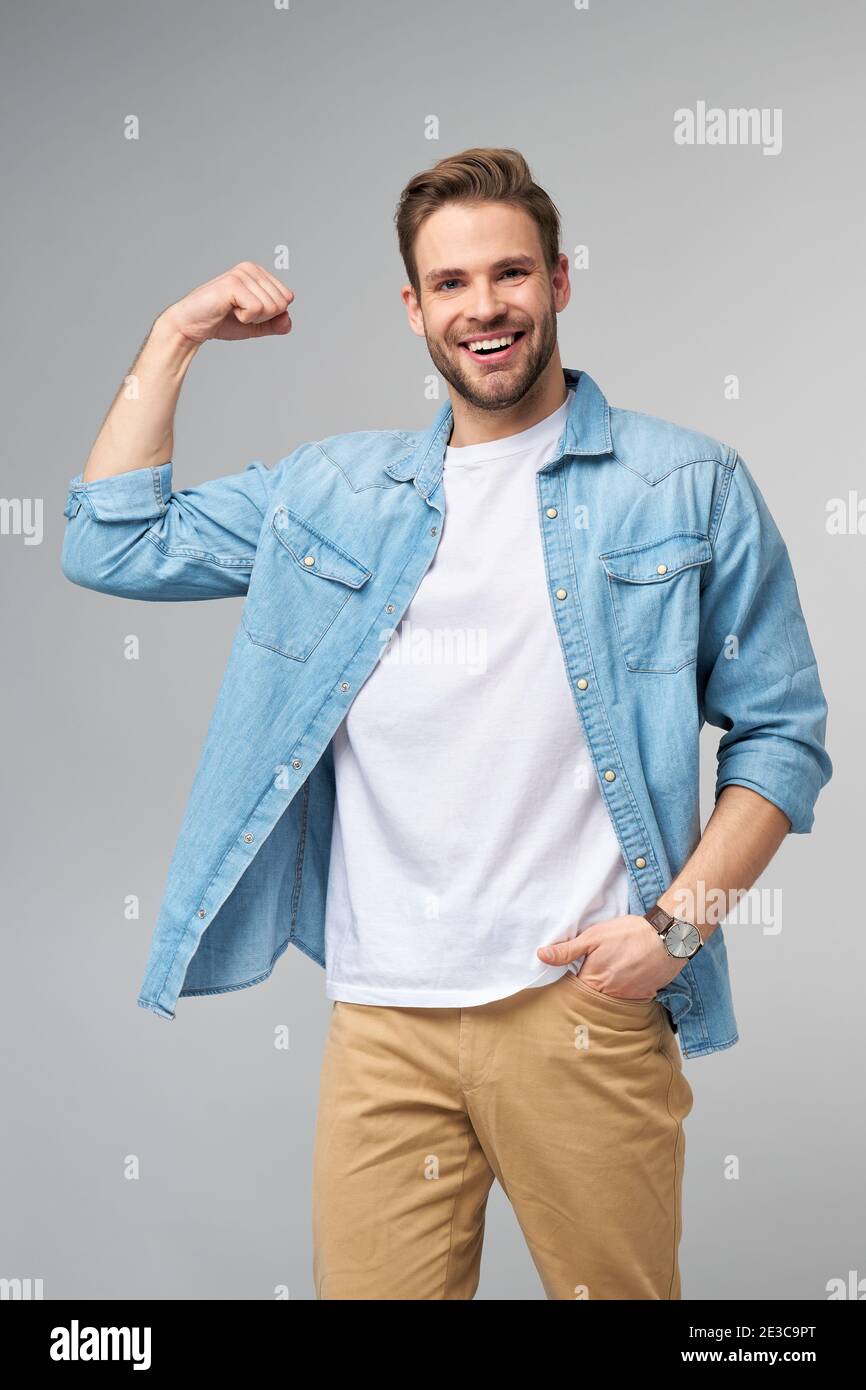 Portrait of a handsome man in jeans shirt showing his bicep with arm ...
