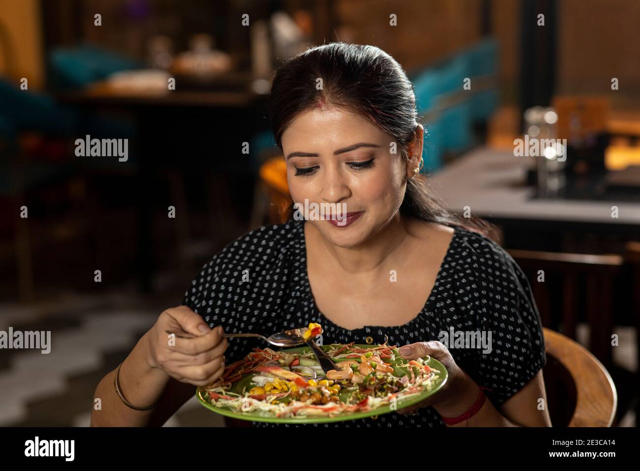 Portrait of a pretty woman eating delicious food in a restaurant Stock ...
