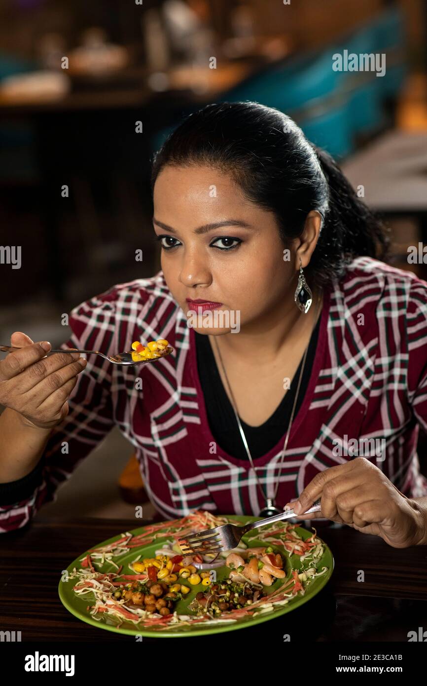 Portrait of a pretty woman eating delicious food in a restaurant Stock ...