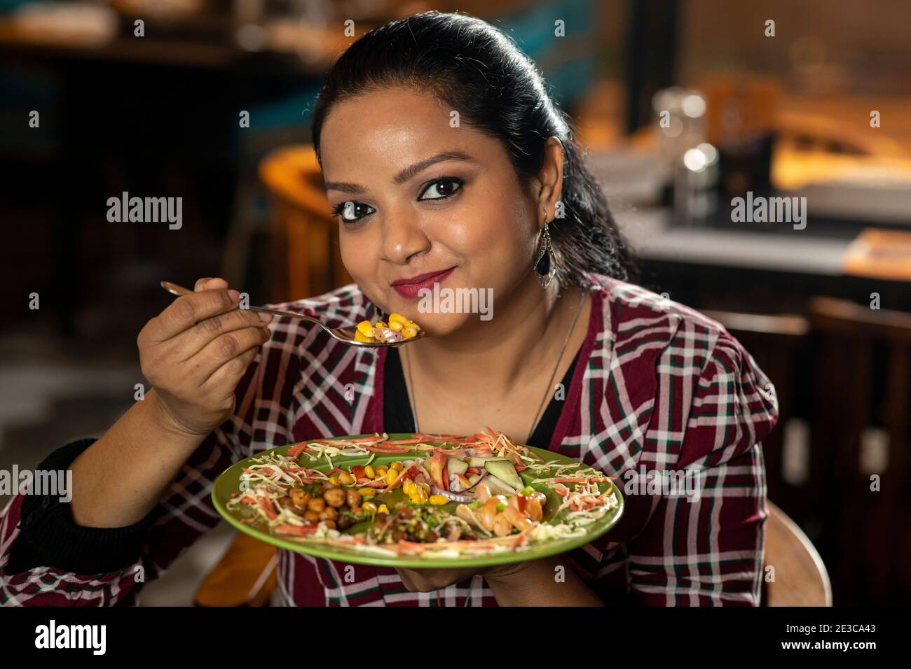 Portrait of a pretty woman eating delicious food in a restaurant Stock ...