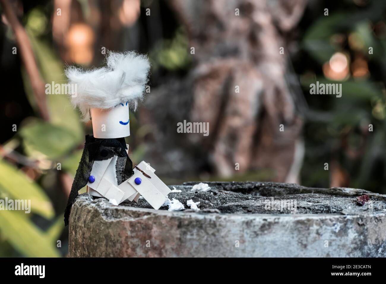 A handmade cardboard dummy wearing a scarf and a furry cap sitting on a ...