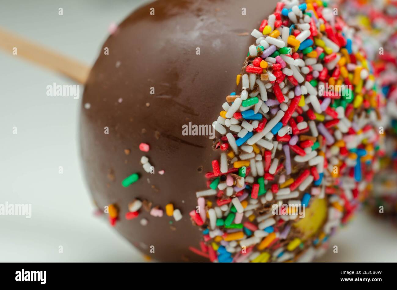 Candy apple coated with milk chocolate and covered with colorful sweet ...