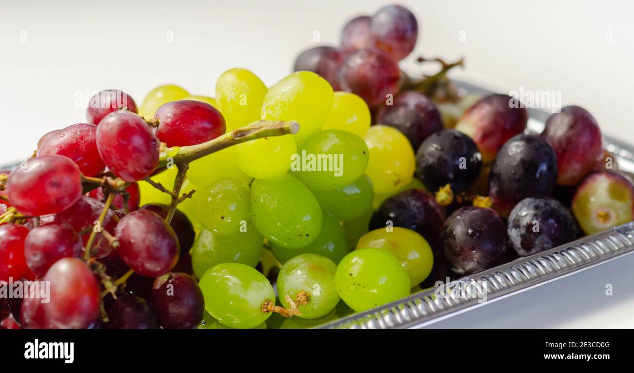Three types of green, red and black grapes on a silver tray, fresh ...