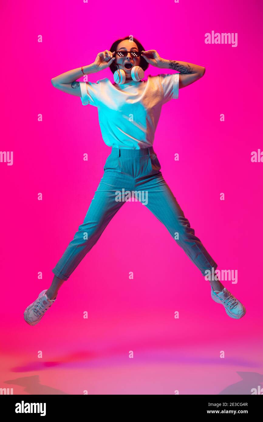 Jumping high. Caucasian woman's portrait on pink studio background in ...