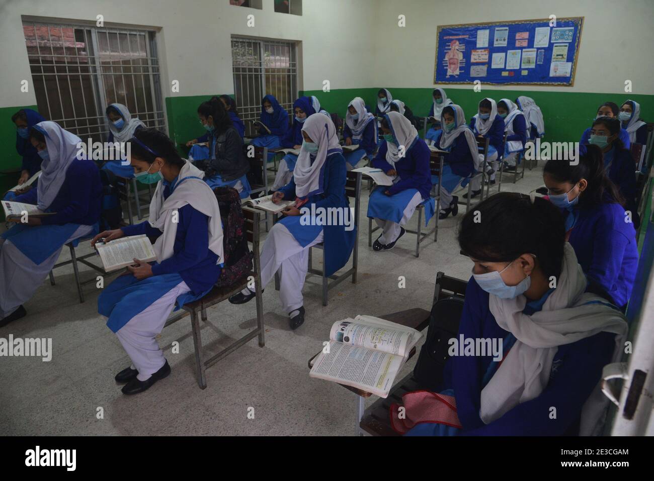 Pakistani students wearing facemasks to attend their first day of ...